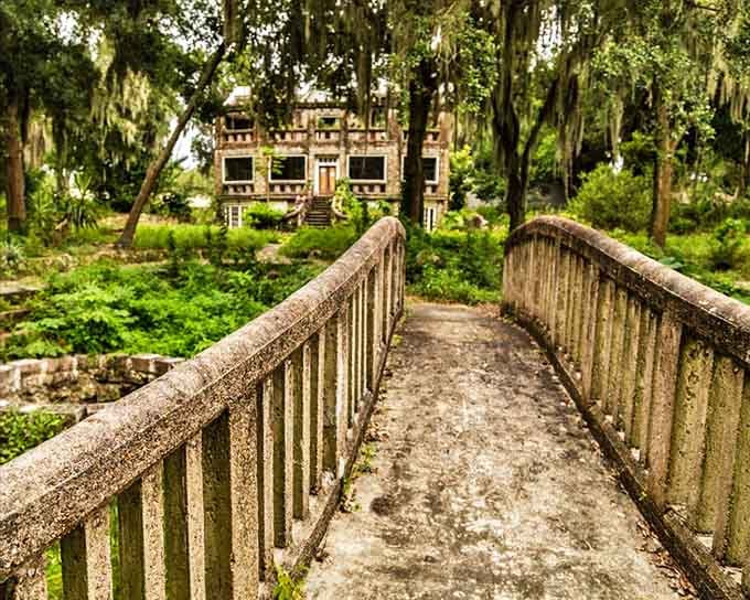 The Wonder House emerges from lush Florida greenery like a concrete dream, its weathered facade telling stories of eccentric vision and Jazz Age ambition.