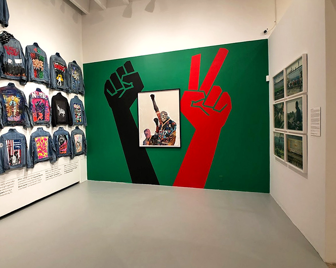 Artists In Protest: Powerful fists raised against vibrant green showcase how spray cans became weapons of mass expression when conventional channels failed marginalized communities.
