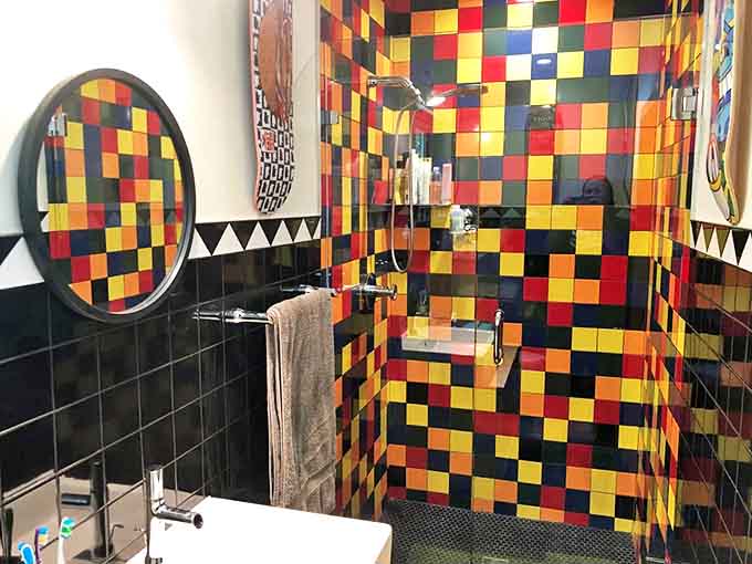 The bathroom's checkerboard tile explosion turns a simple shower into an immersive art installation &ndash; functionality with a serious splash of fun.