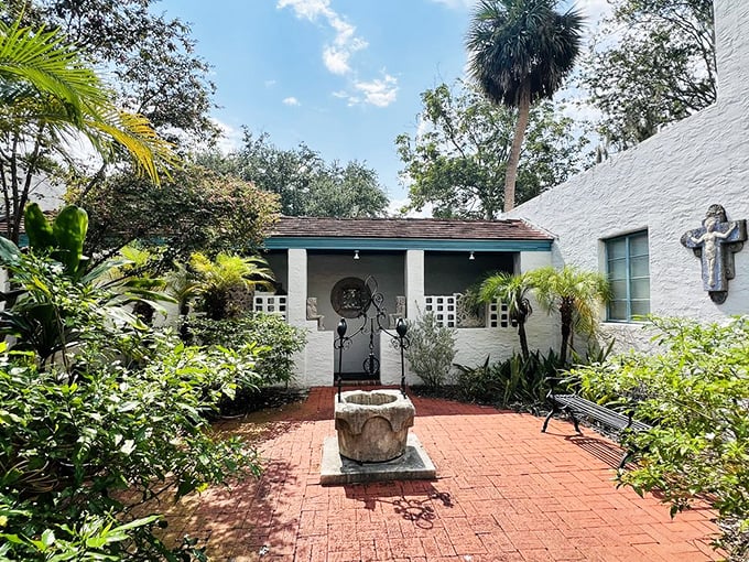 A stone fountain anchors this intimate brick courtyard, creating a Mediterranean-inspired oasis where visitors can pause and reflect.