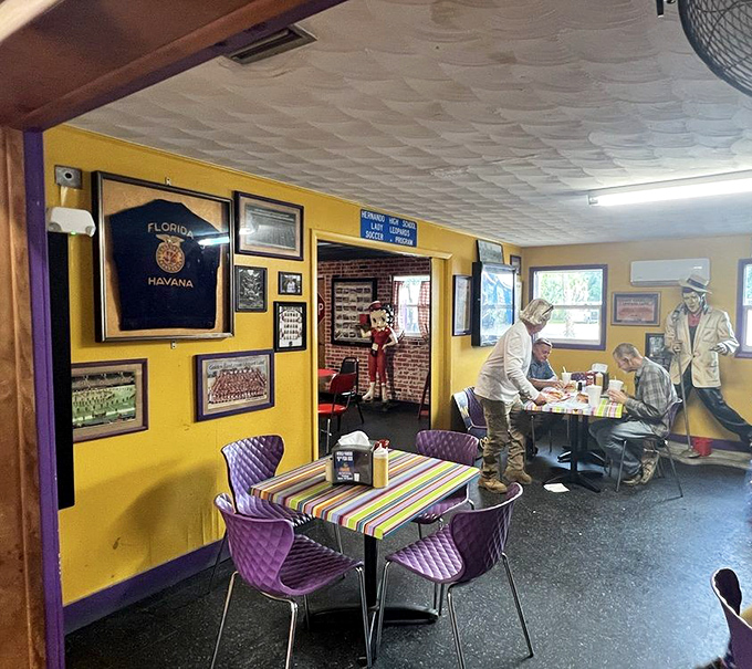 The dining area's vibrant yellow walls and purple chairs create a cheerful contrast to the nostalgic memorabilia covering every available surface.