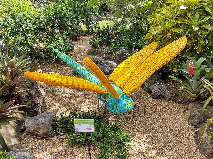 This vibrant dragonfly sculpture hovers magically among the greenery, its wings catching sunlight like stained glass windows in nature's cathedral.