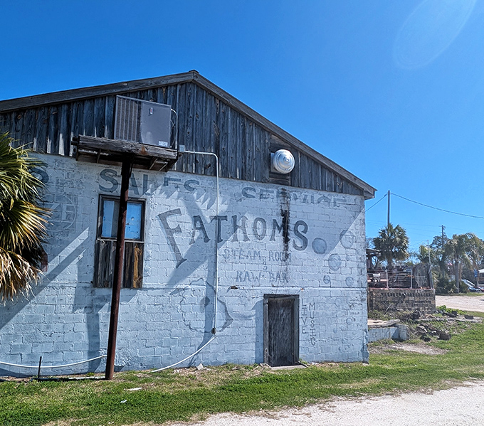 Fathoms' faded signage tells tales of commerce past – a ghost sign that whispers stories of Carrabelle's working waterfront heritage.