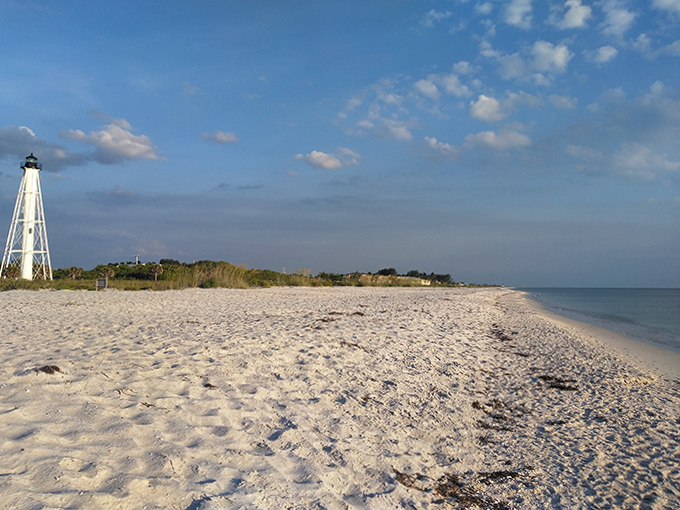 The lighthouse beach stretches toward infinity, offering shell-seekers and solitude-hunters equal treasures along its pristine shore.