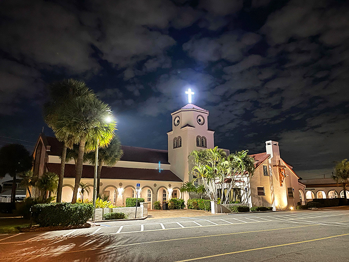 After sunset, the illuminated church takes on a magical quality, its cross glowing against the night sky.