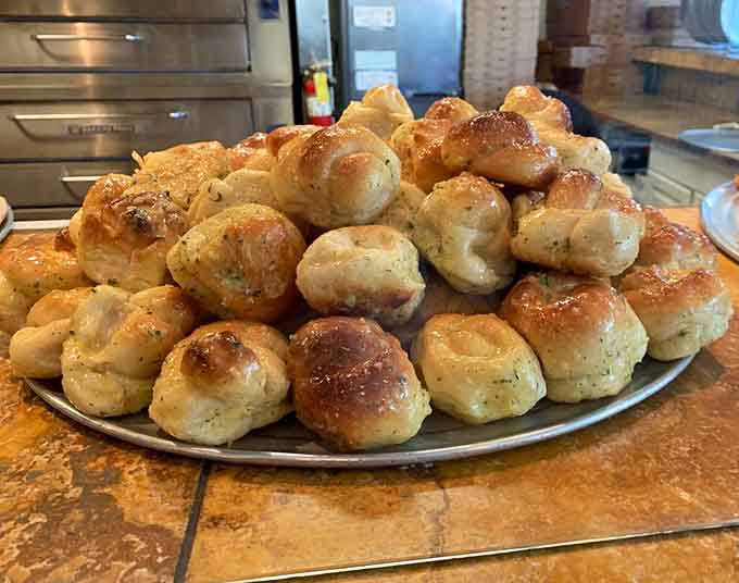 Garlic knots at Pino's are dangerously addictive little butter bombs that'll ruin your appetite in the best way.