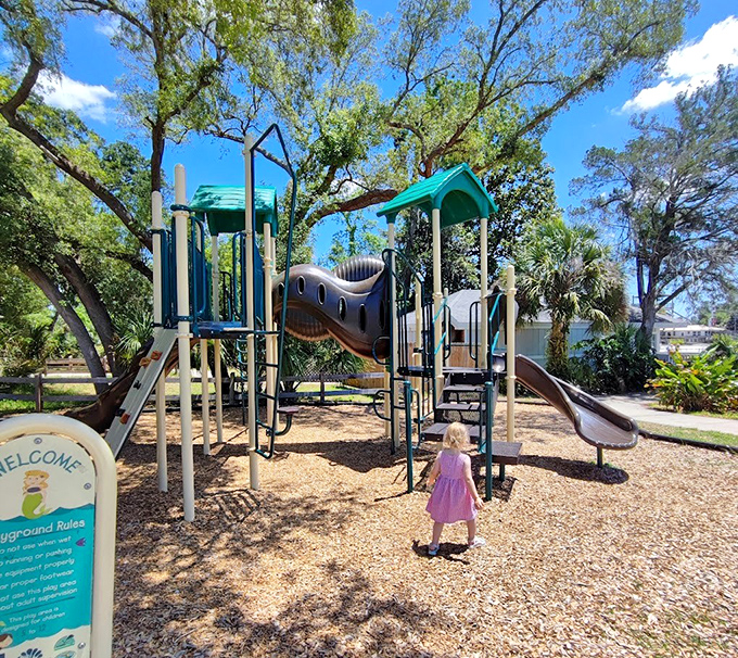 Little adventurers explore the nautical-themed playground, burning energy while parents enjoy a moment's respite under swaying palms.