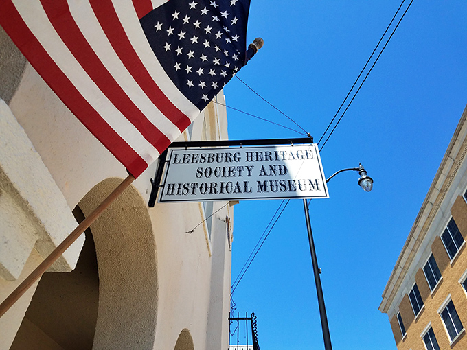 The American flag flutters proudly beside the museum's sign, a patriotic sentinel guarding stories of those who built this slice of Americana.