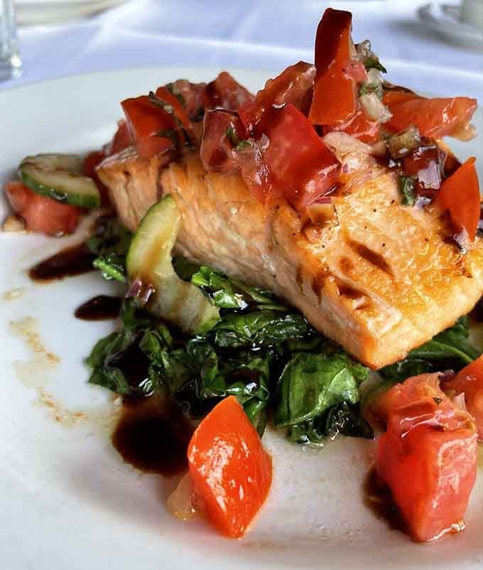 Fresh salmon over saut&eacute;ed spinach and tomatoes brings the ocean to your table in the most delicious way.
