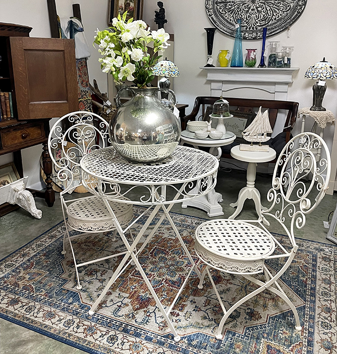 This delicate wrought iron bistro set practically begs for morning coffee and croissants, its weathered white finish whispering tales of Parisian caf&eacute;s.