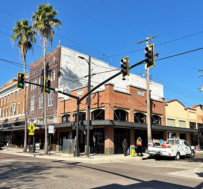 Downtown Ybor's historic buildings frame modern street life, where construction crews work to balance preservation with progress in this evolving district.