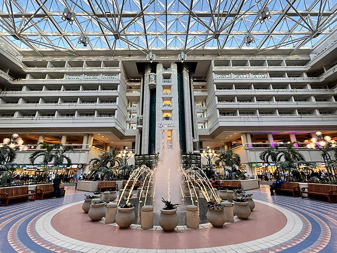 Orlando Airport's central fountain creates a tropical oasis atmosphere, making waiting for flights slightly less painful for actual humans.