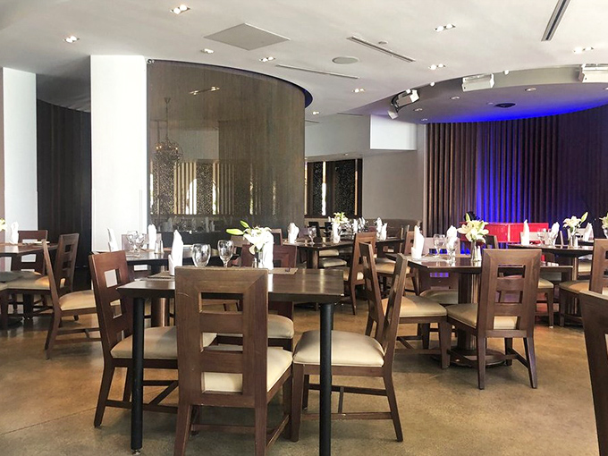 Warm wood tones and strategic lighting create an intimate dining atmosphere where every table feels like the best seat in the house.