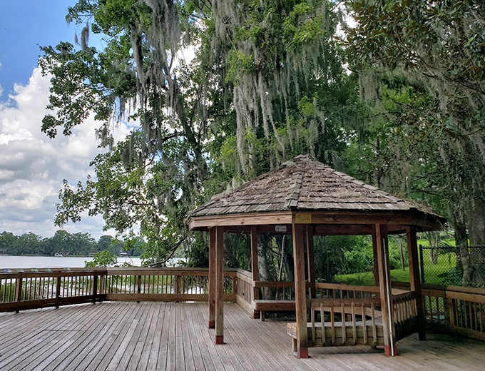 Spanish moss sways gently above this wooden gazebo, creating a quintessentially Southern scene that feels worlds away from nearby theme parks.