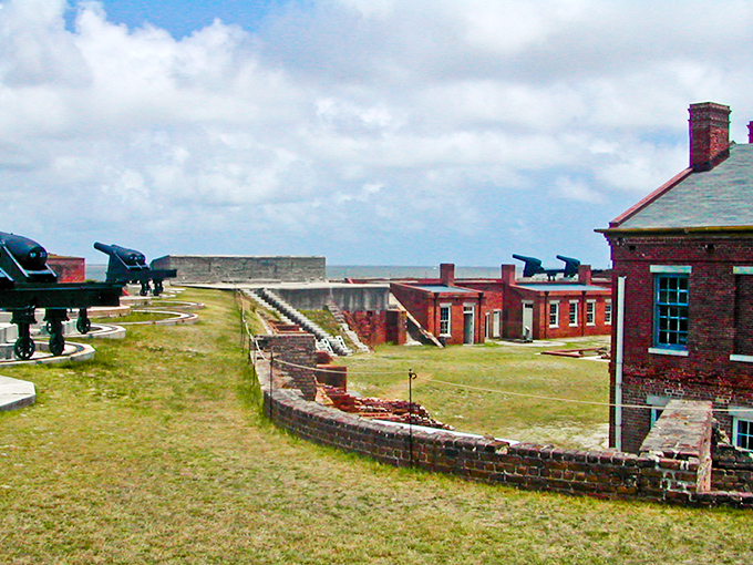 The imposing brick walls of Fort Clinch stand against a clear blue sky, their pentagonal design a testament to military engineering.