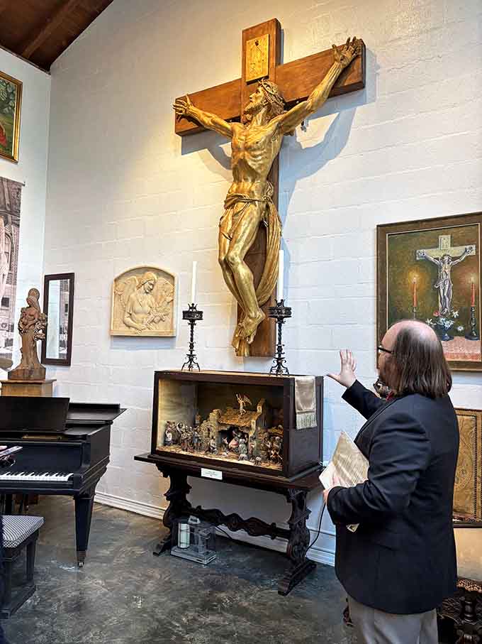A golden crucifix commands the gallery space, flanked by candles and surrounded by art that whispers rather than shouts.