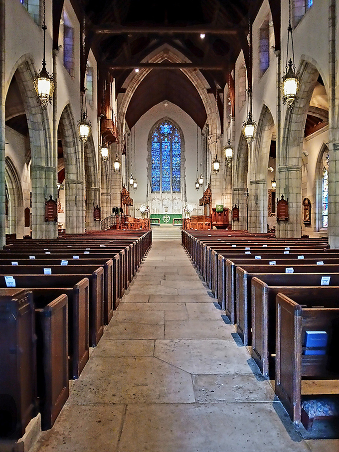 Wooden pews stand in patient formation beneath hanging lanterns, waiting for the next service or the next awestruck visitor seeking a moment's peace.