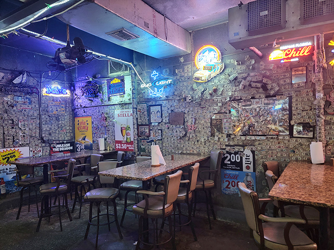 Neon beer signs illuminate walls of dollar bills in this snug dining space where strangers become friends over shared seafood platters.