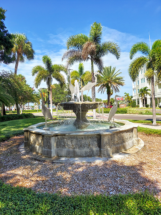 The fountain's elegant herons remain forever mid-flight, surrounded by the refreshing soundtrack of cascading water on warm Florida days.