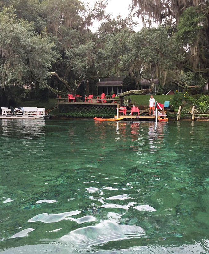 The water's emerald-green hue looks like something from a fantasy novel, creating a swimming experience that feels more like floating through liquid gemstones than your typical dip in a river.