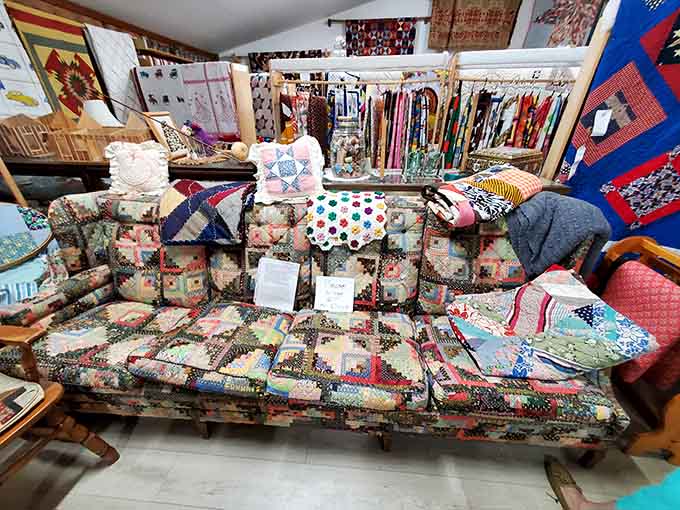 Stacks of patchwork quilts overflow with patterns and colors that would make a rainbow jealous of their wardrobe.