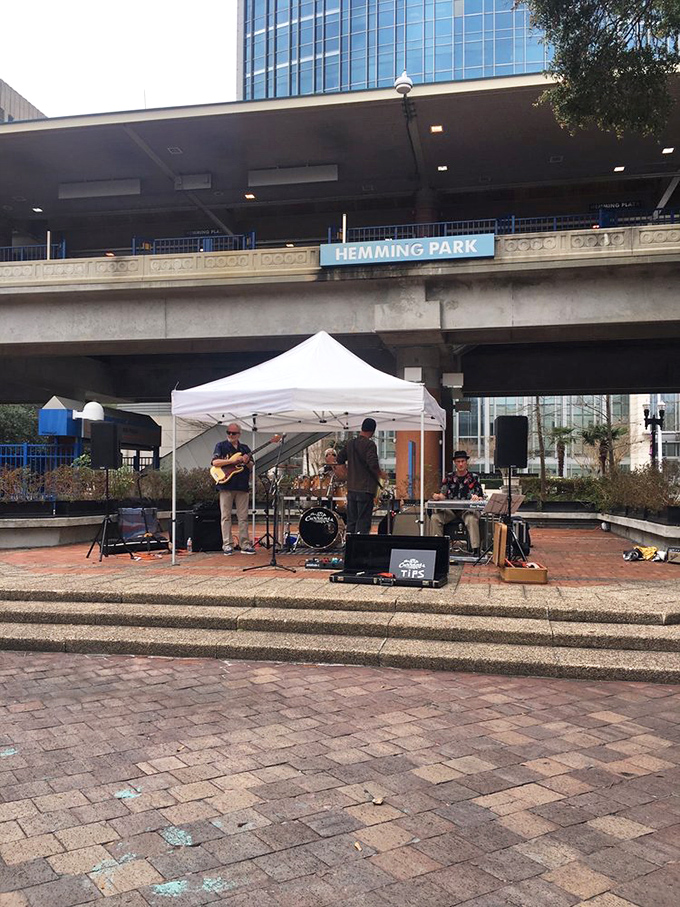 Live music fills the air as local musicians perform under the Hemming Park sign, creating the perfect soundtrack for a lazy afternoon.