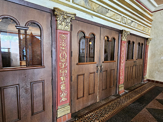 Ornate wooden doors with decorative panels stand ready to usher guests into another world &ndash; the threshold between ordinary life and cinematic escape.