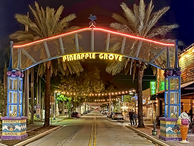 The Pineapple Grove Arts District gateway arches over the street like a tropical rainbow, illuminating Delray's artistic heart after dark.
