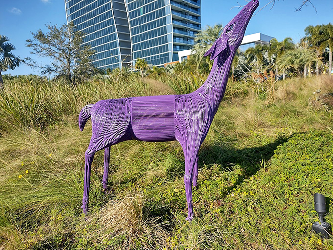 This purple wire deer stands like a vibrant apparition against the landscape, its translucent form shifting with changing light.