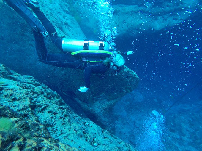 Solo diving through crystal-clear water offers a meditative experience, assuming your idea of meditation involves breathing apparatus and limestone walls.