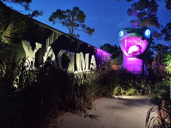 Yacuma's illuminated snake head watches over visitors with glowing eyes, transforming from water attraction by day to eerie landmark by night.