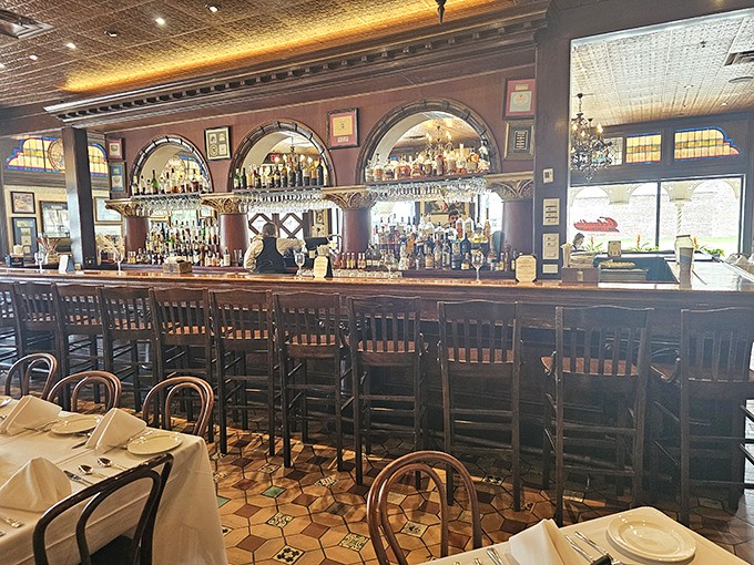 The bar area balances old-world charm with modern hospitality, where bartenders craft cocktails beneath arched windows that have witnessed a century of celebrations.