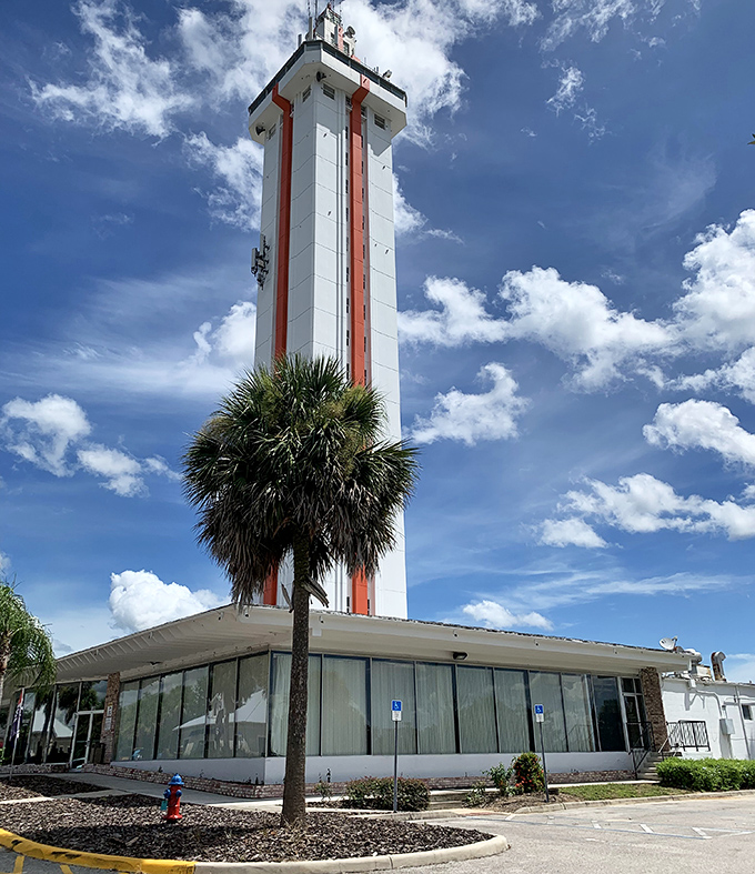 Palm trees frame the tower's base like nature's own welcome committee, a quintessentially Florida greeting for visitors approaching this landmark.