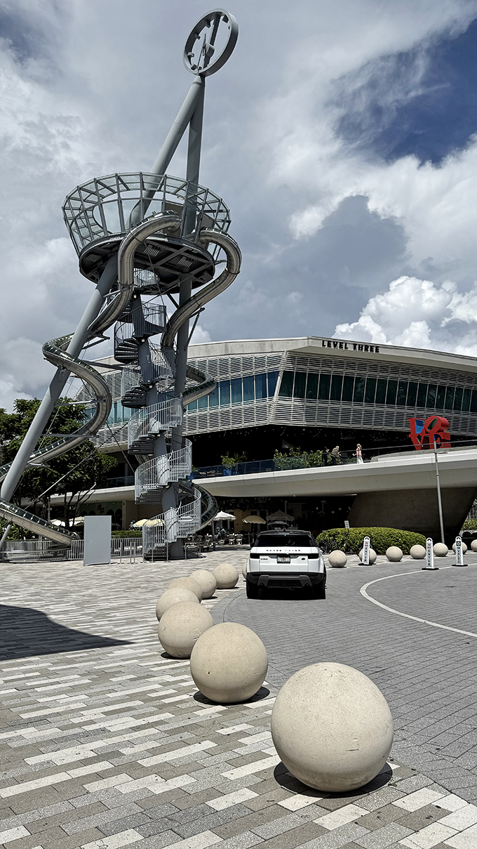 The tower stands as a silver sentinel against blue skies, its distinctive silhouette becoming an unexpected landmark in Aventura's landscape.