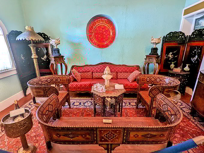 This crimson-cushioned seating arrangement once welcomed guests to relax amid hand-knotted rugs and mother-of-pearl inlaid tables.