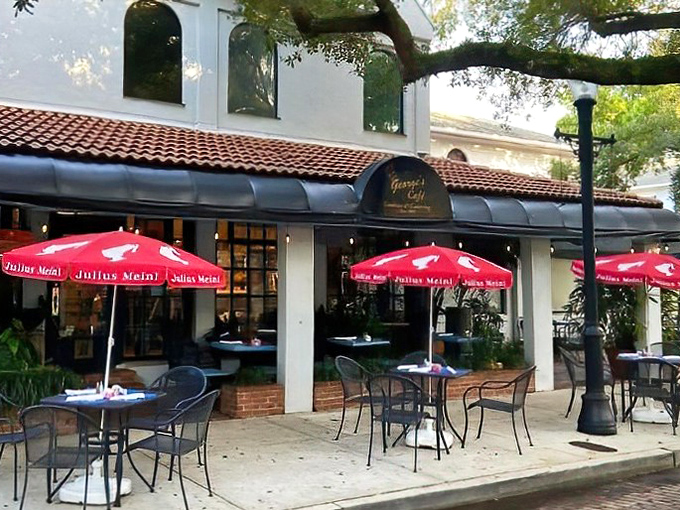 George's Caf&eacute; invites diners to linger under red umbrellas, where Mediterranean flavors complement the town's architectural influences.