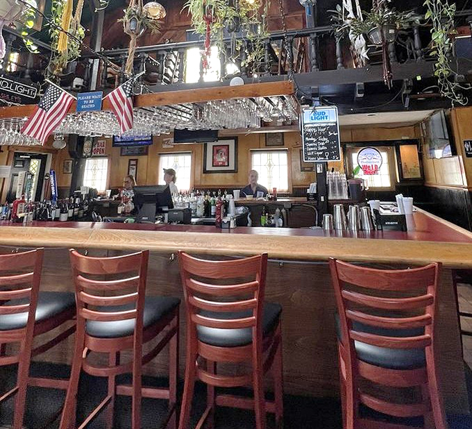 Hanging glassware catches the light above the bar, where some say glasses have been known to move on their own after hours.