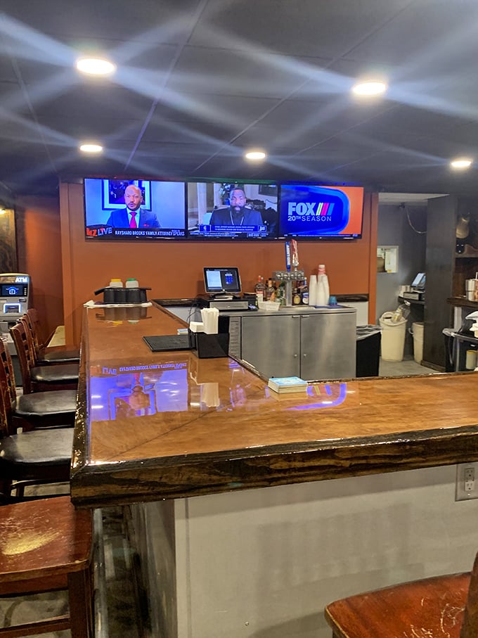 The polished wood bar reflects decades of elbows, stories, and raised glasses &ndash; a front-row seat to both the game on TV and life's little dramas.