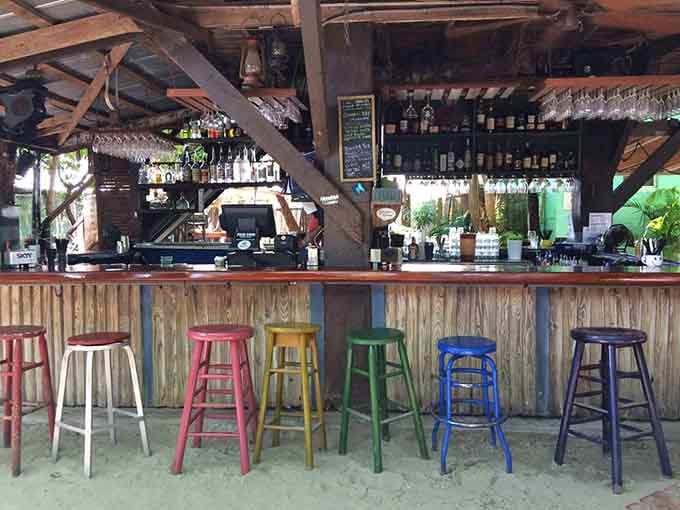 Rainbow stools lined up like a pride parade decided to take a permanent seat at the bar.