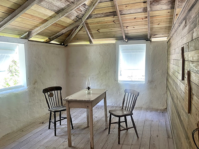 Simplicity speaks volumes in this settler's room, where a wooden table, two chairs, and natural light were all a family needed for daily living.