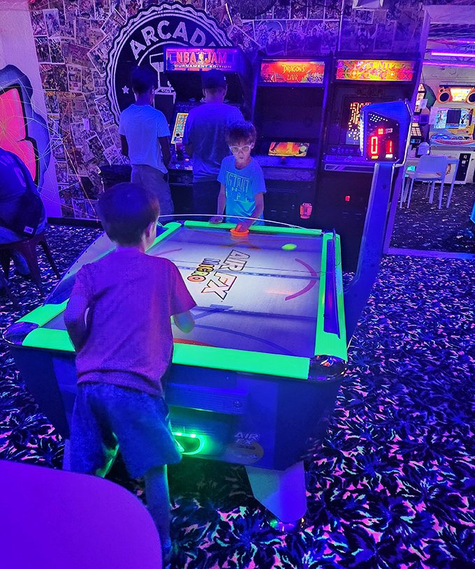 Air hockey intensity: The concentrated focus of youth at play. That puck moves at the speed of childhood – fast, unpredictable, and thrilling.