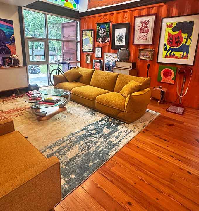 The living room's mustard sofa anchors the space with mid-century flair, while surrounding artwork ensures your eyes never rest in one place too long.