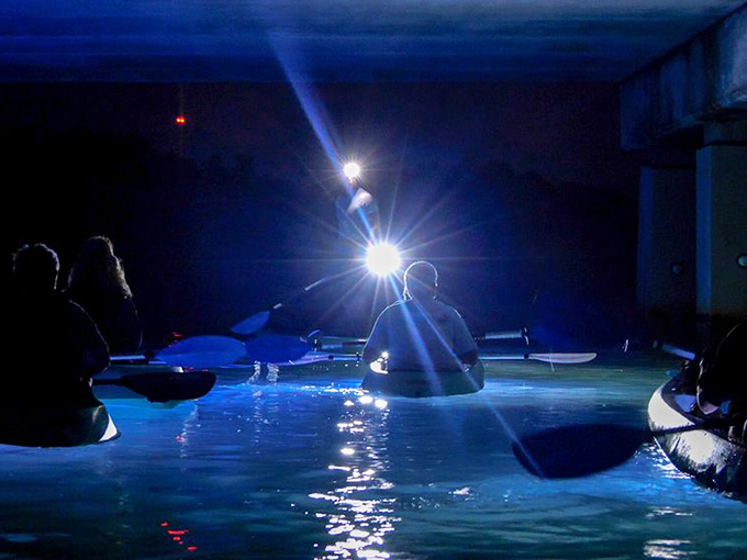 Nighttime paddling: Headlamps cut through darkness as kayakers form a floating circle of light, creating an impromptu water lantern festival.
