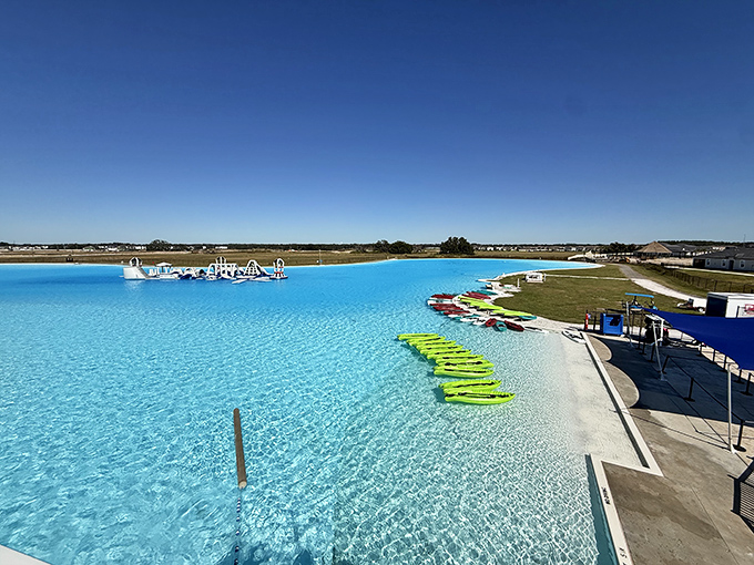 The lagoon's edge reveals its perfect gradient from shallow to deep, with kayaks awaiting adventurers ready to explore beyond the shore.