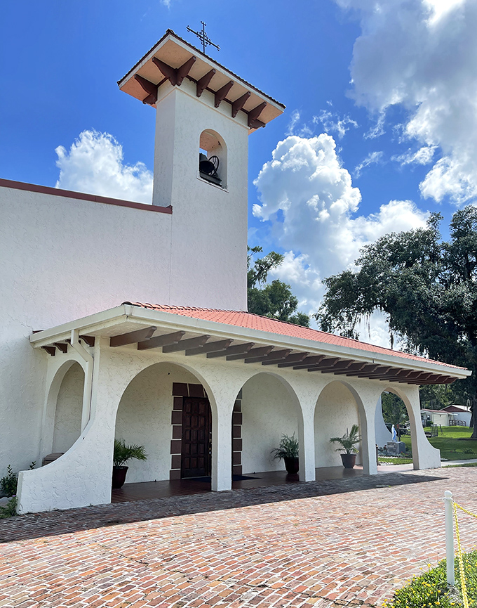 St. Rita Catholic Church's mission-style architecture and bell tower create a spiritual landmark against Florida's cloud-dotted sky.