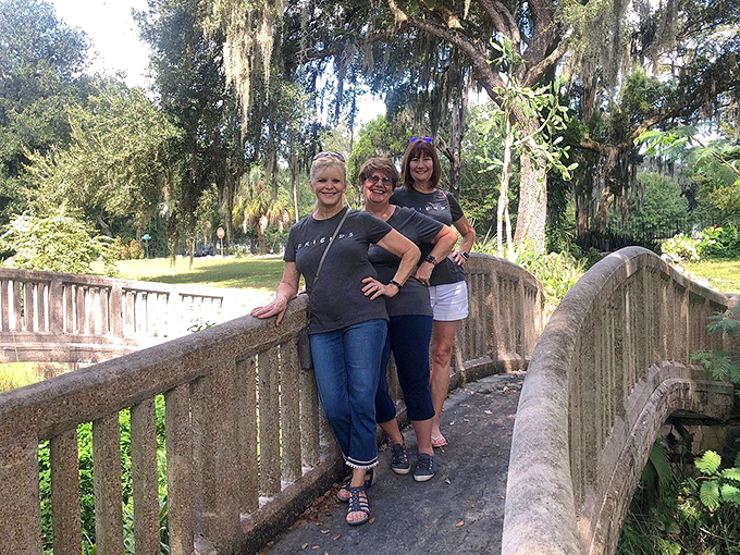 Visitors pause on one of the property's many concrete bridges, momentarily becoming part of the Wonder House's ongoing story.