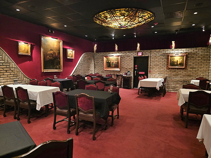 The dining room balances old-world charm with timeless elegance, where red velvet chairs invite you to settle in for a memorable feast.