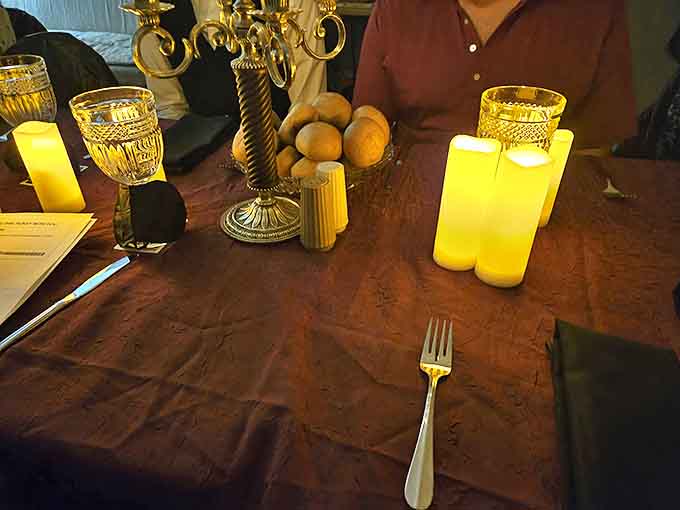 Séance setting: Flickering candles cast dancing shadows across the antique dining table, setting the perfect scene for communing with spirits.