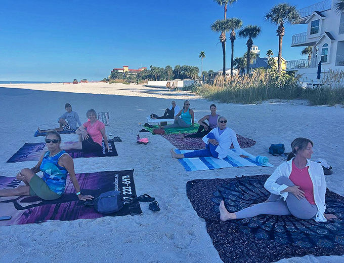 A multi-generational group sits in meditation on their beach mats, proving that finding your zen knows no age limit, especially with an ocean view.