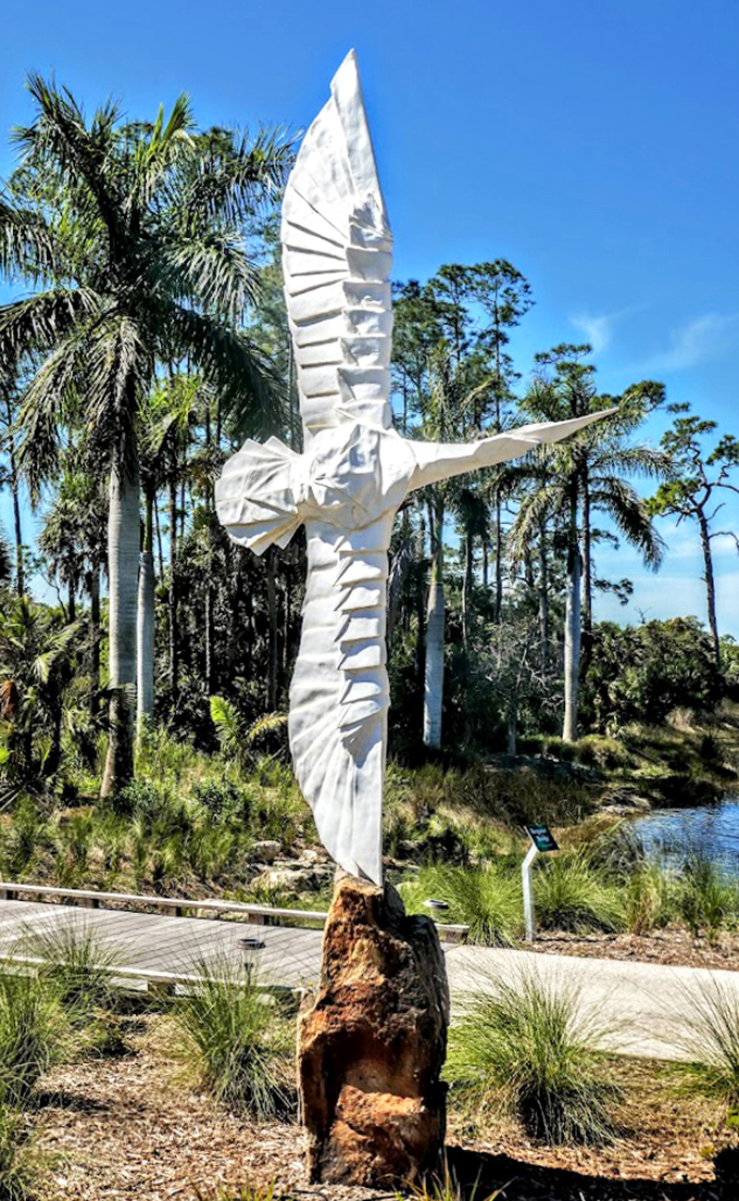 Taking flight in perpetual departure, this striking white sculpture soars against a backdrop of native Florida palms.